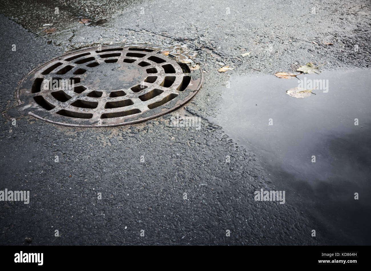 Round sewer manhole cover in urban asphalt pavement Stock Photo - Alamy