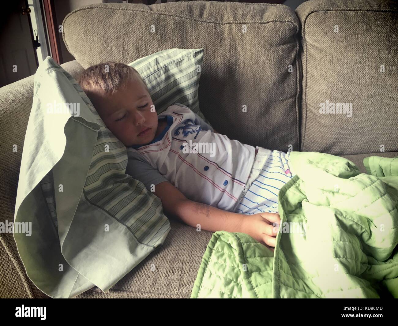 Boy sleeping on a couch Stock Photo - Alamy