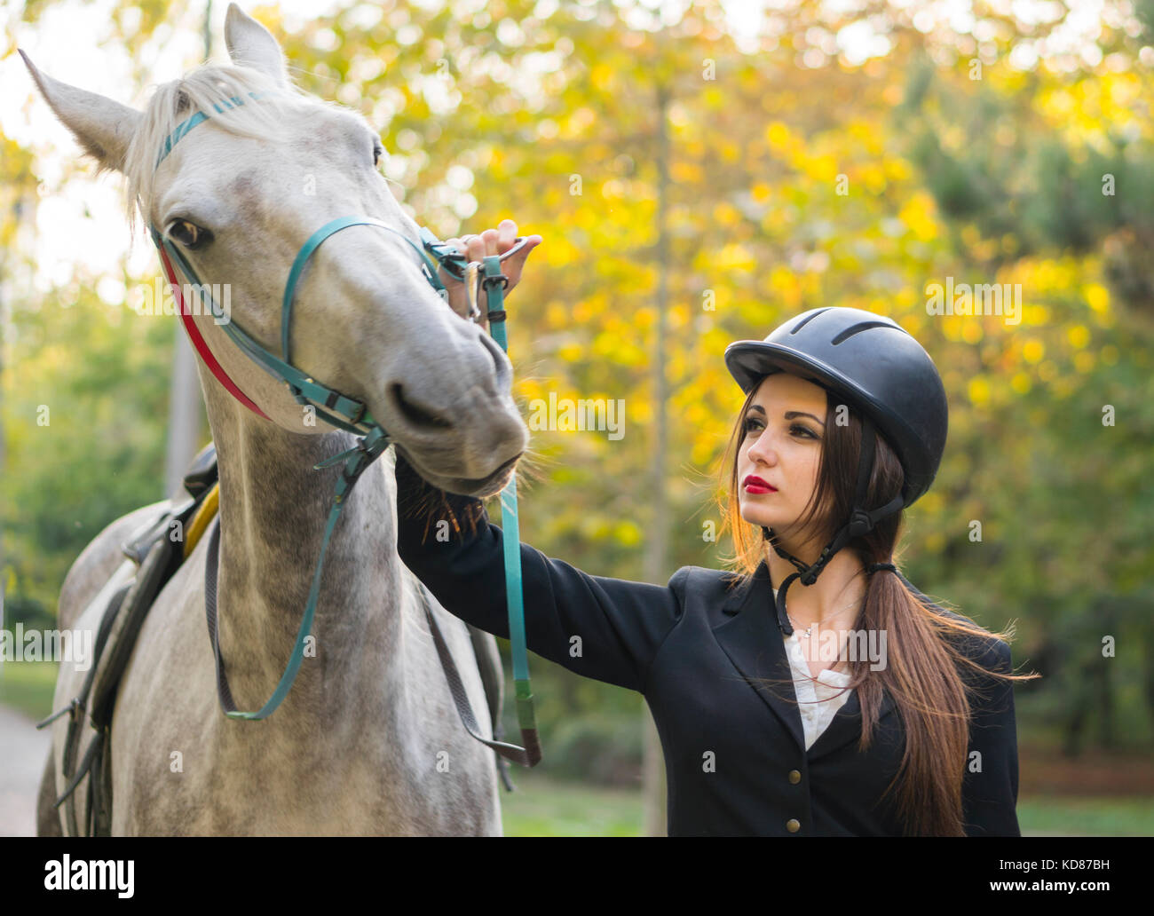 Young brunette beauty girl having fun with horse in the park Stock ...