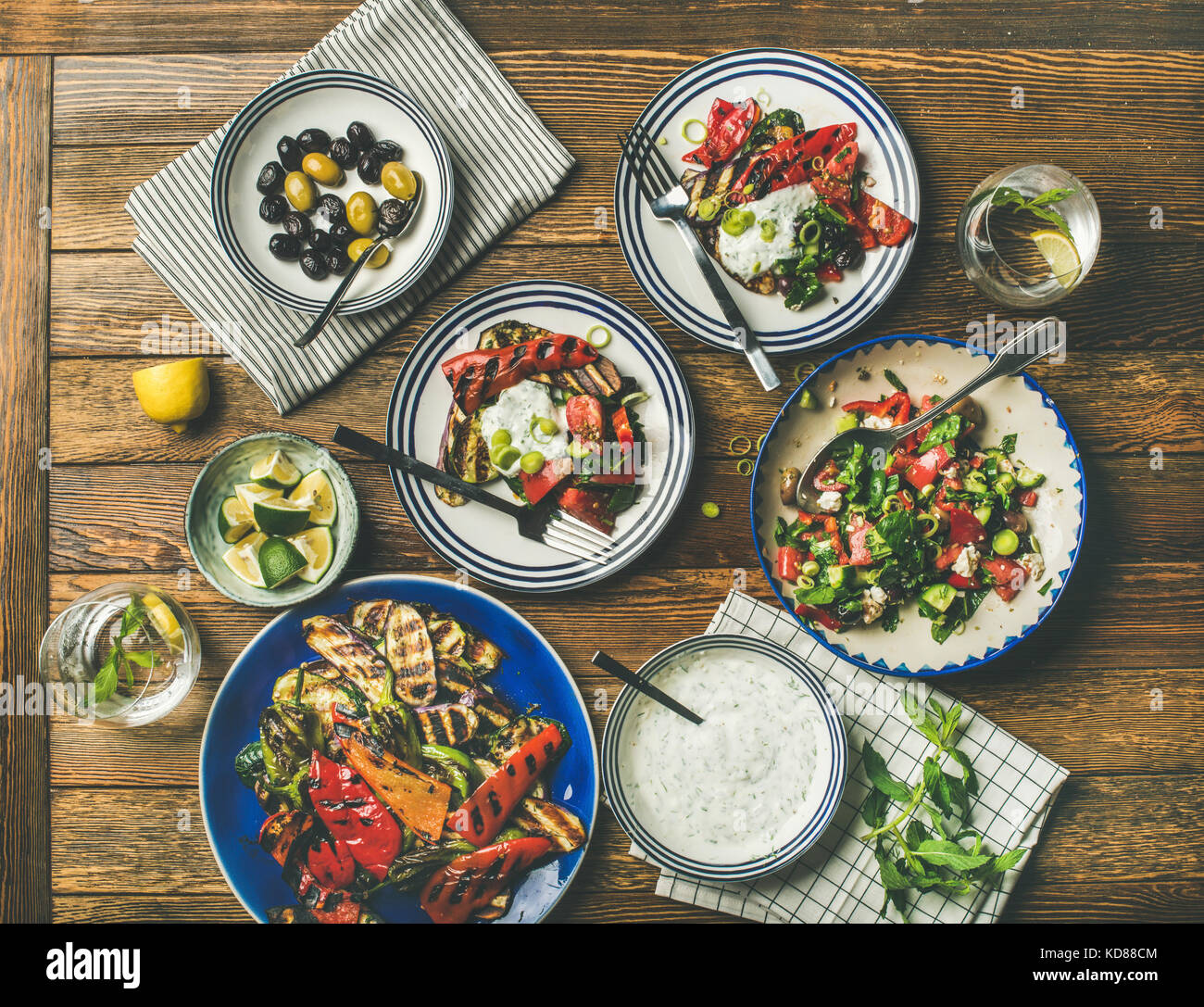 Flat-lay of healthy dinner table setting. Fresh salad, grilled ...