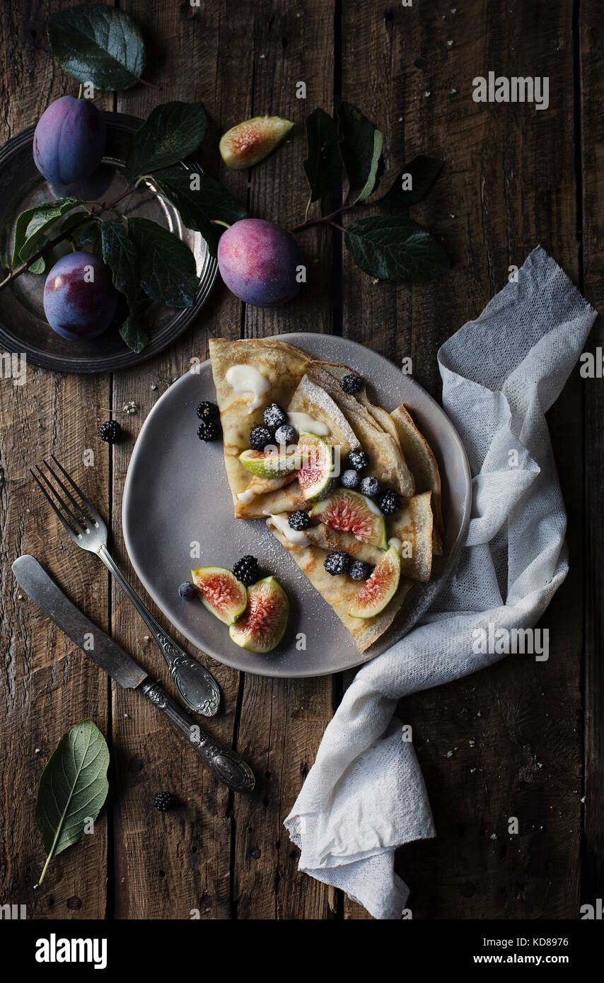 Crepes with figs and blackberries on wooden table. Top view Stock Photo ...