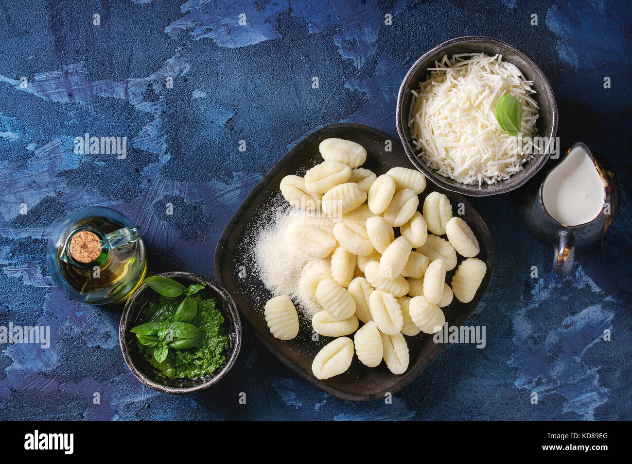 Raw uncooked potato gnocchi in black wooden plates with ingredients ...
