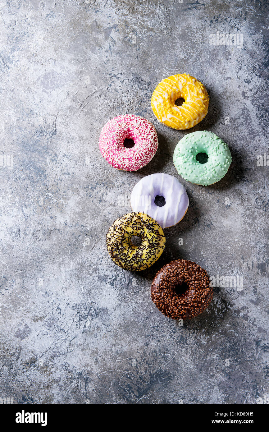 Variety of colorful glazed donuts over gray texture background. Top ...