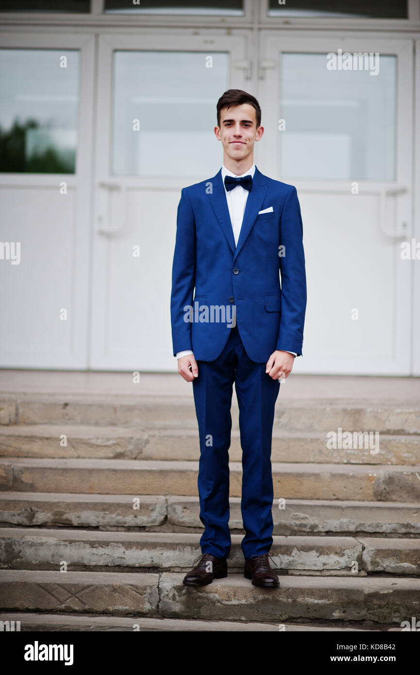 Portrait of a handsome high school graduate in stylish tuxedo posing on ...