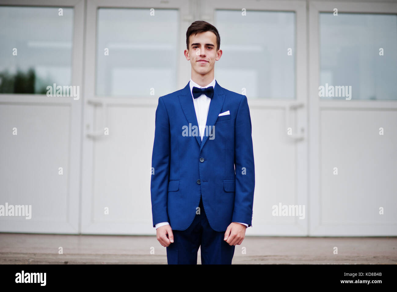 Portrait of a handsome high school graduate in stylish tuxedo posing on ...
