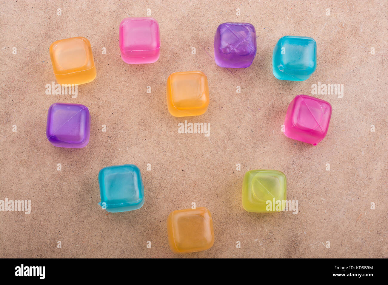 Fake colorful ice cubes on a brown background Stock Photo - Alamy