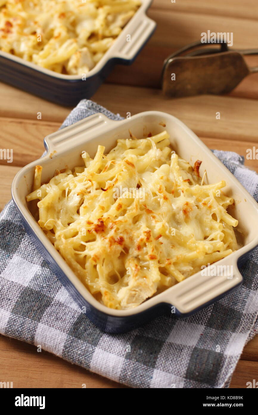 Mac and cheese in blue baking dish over blue and white checkered towel ...
