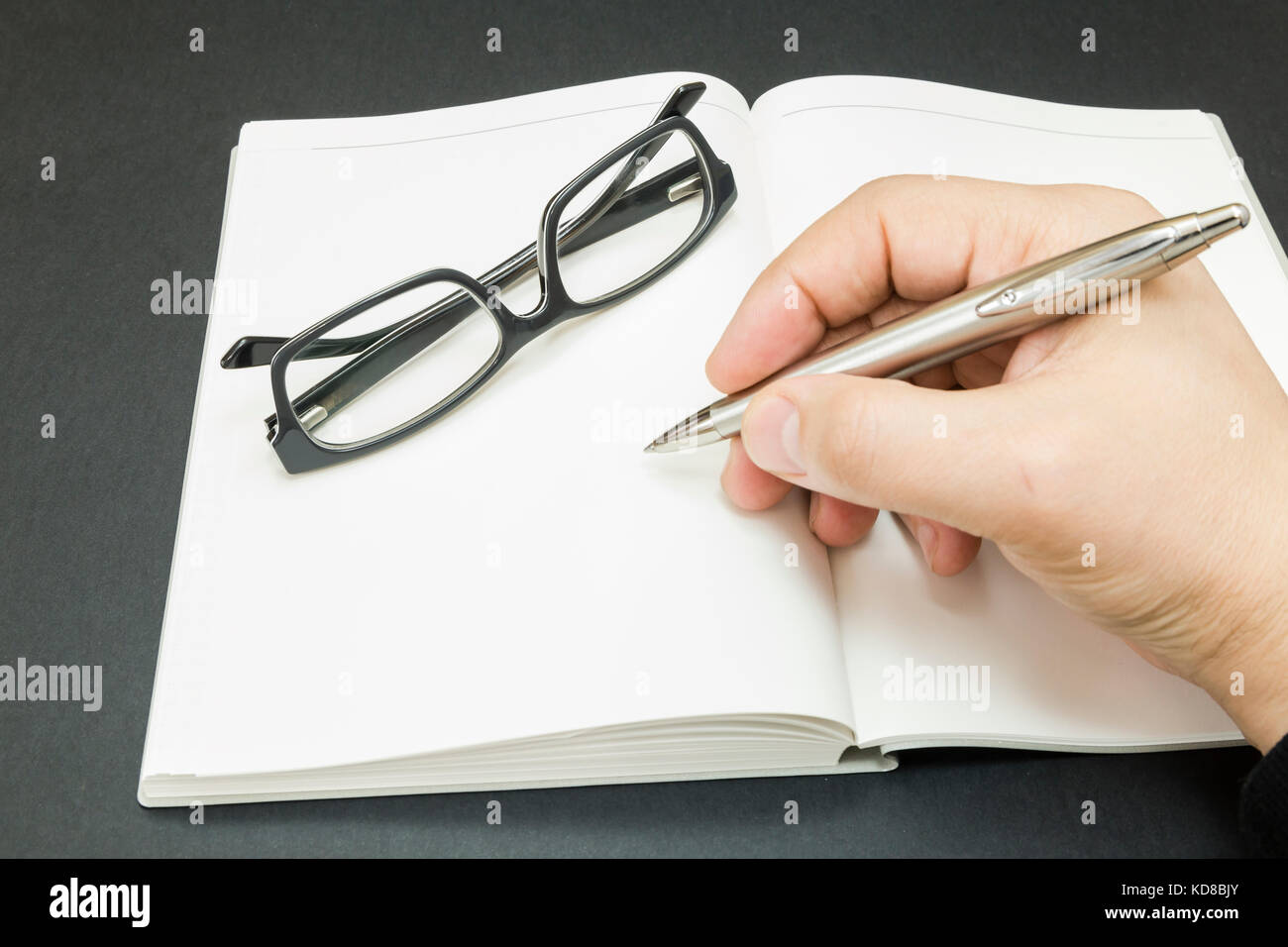 a person beginning to write on a blank book Stock Photo - Alamy