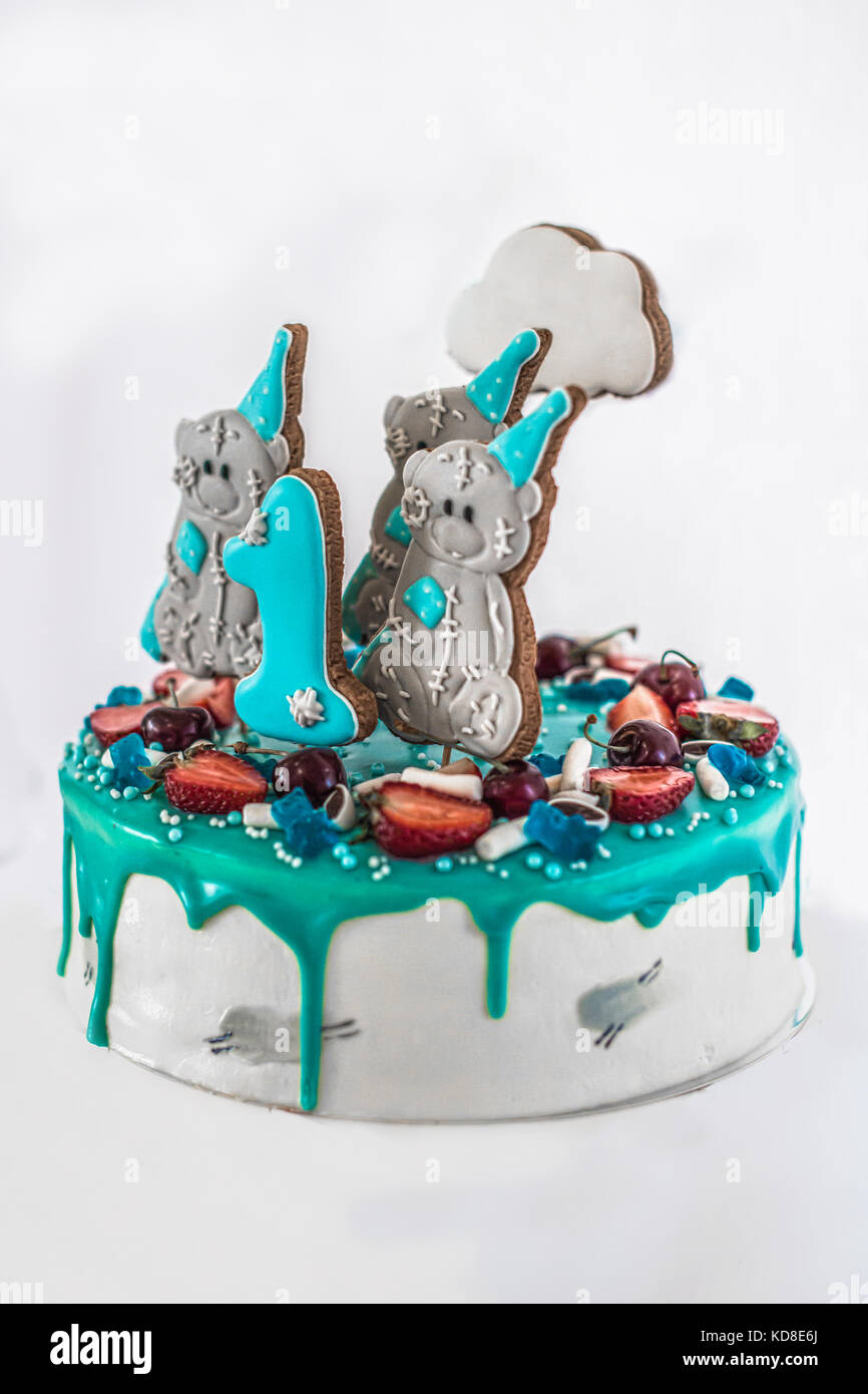 Cake is decorated with a figure number one year and cookies in the form ...