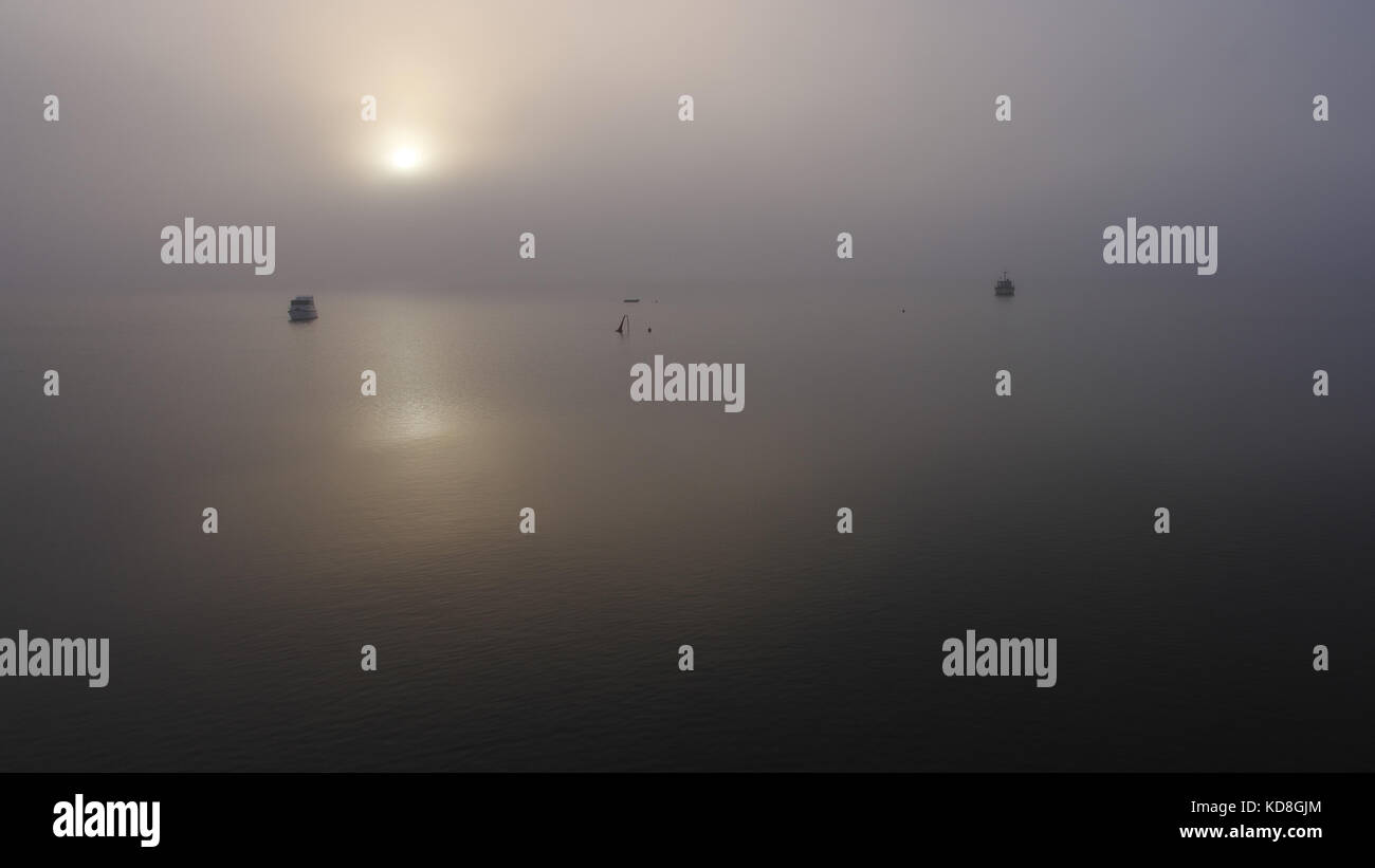 Calm morning sea with a wall of thick fog at the backdrop Stock Photo ...