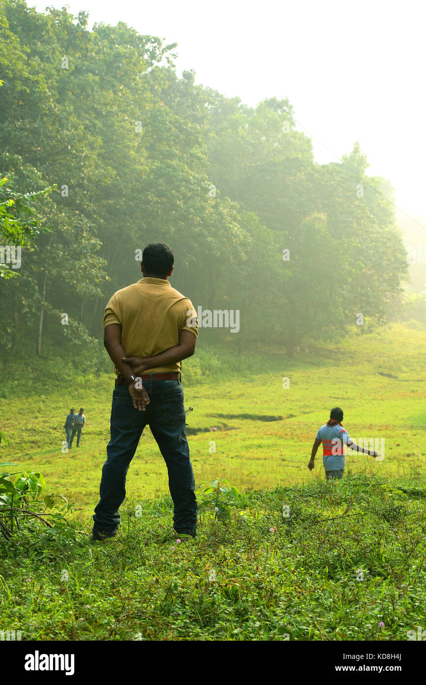 Young man pose and turning back upon camera with a beautiful green ...