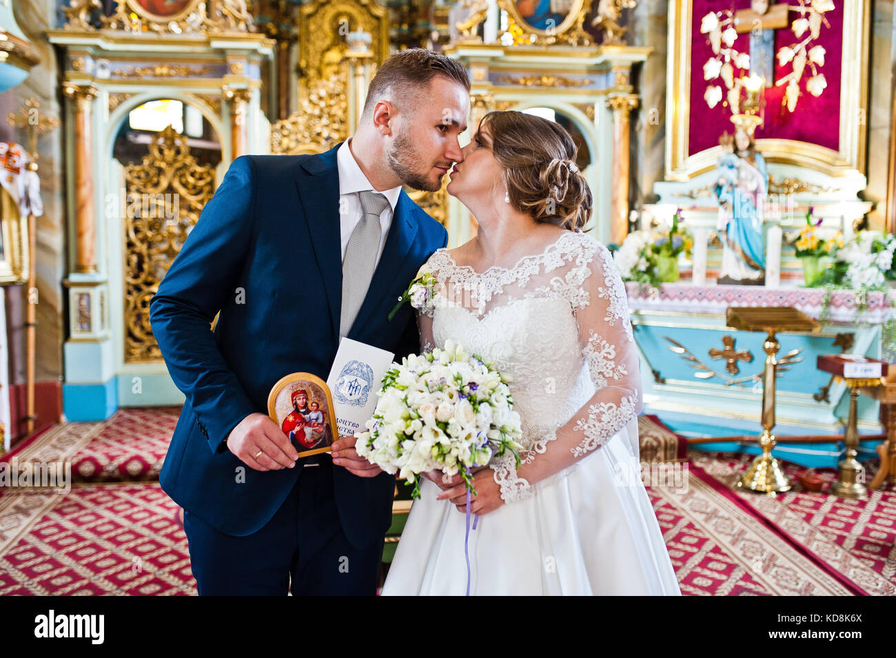 Amazing couple standing and kissing in the church after their wedding ...