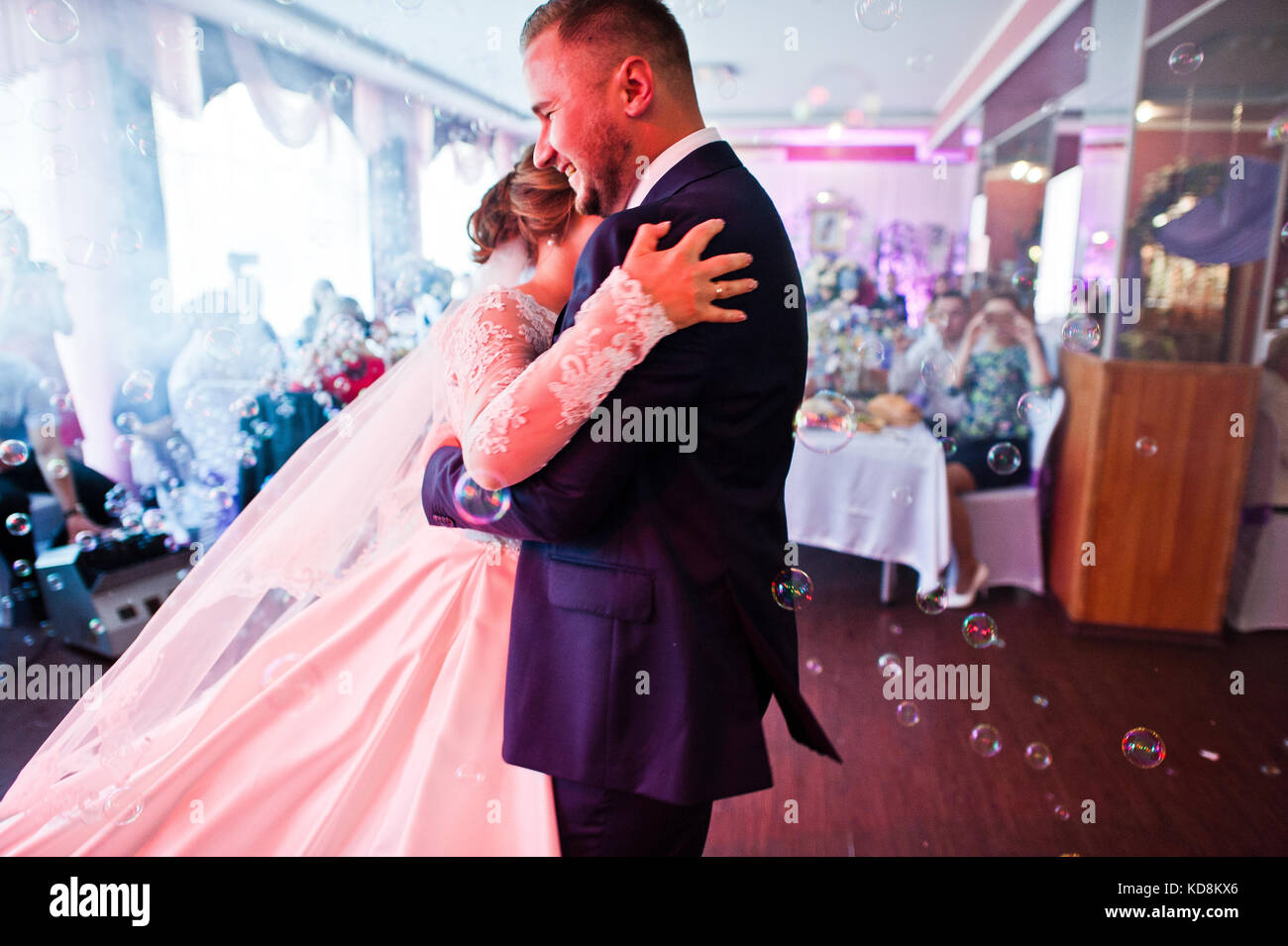 Beautiful wedding couple performing their first dance in the restaurant ...