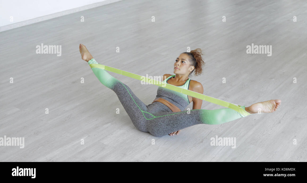 Woman stretching legs with band Stock Photo - Alamy