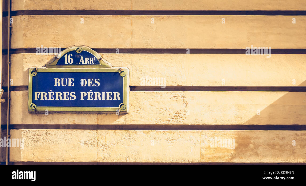 blue parisian street sign on a stone wall where it is written in French ...