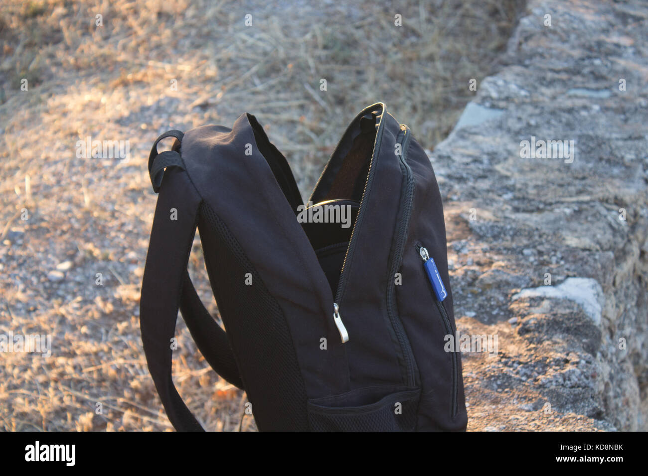 backpack on the edge of a cliff with ocean on the background at a ...