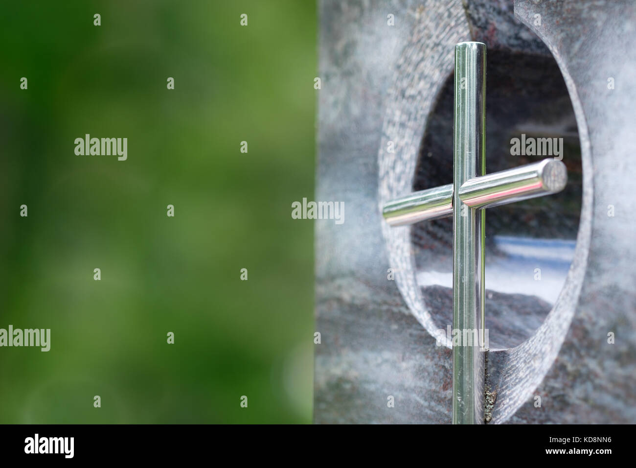 Crucifix at a gravestone with green blurred background Stock Photo - Alamy