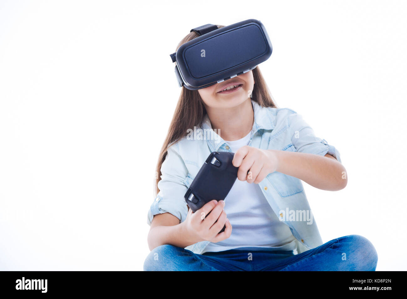 Cheerful cute girl holding a game console Stock Photo - Alamy