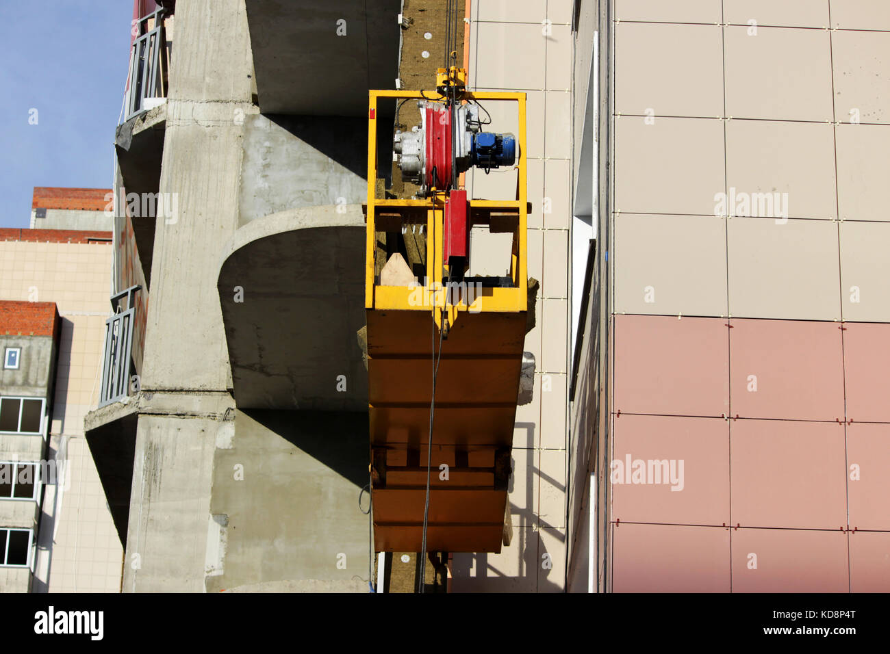work with yellow front two suspended cradle with workers on a newly ...