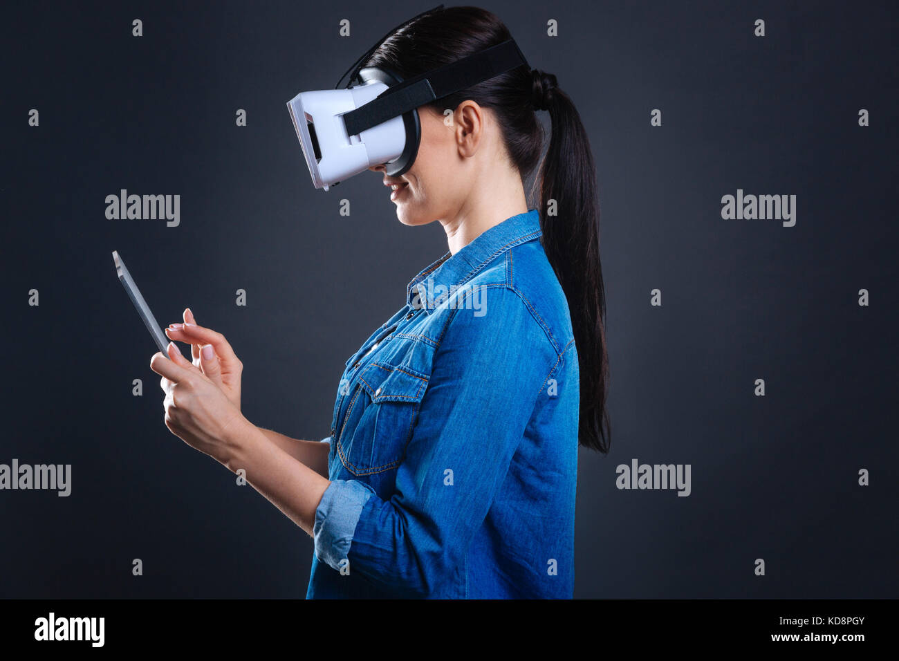 Cheerful positive woman using electronic device Stock Photo - Alamy