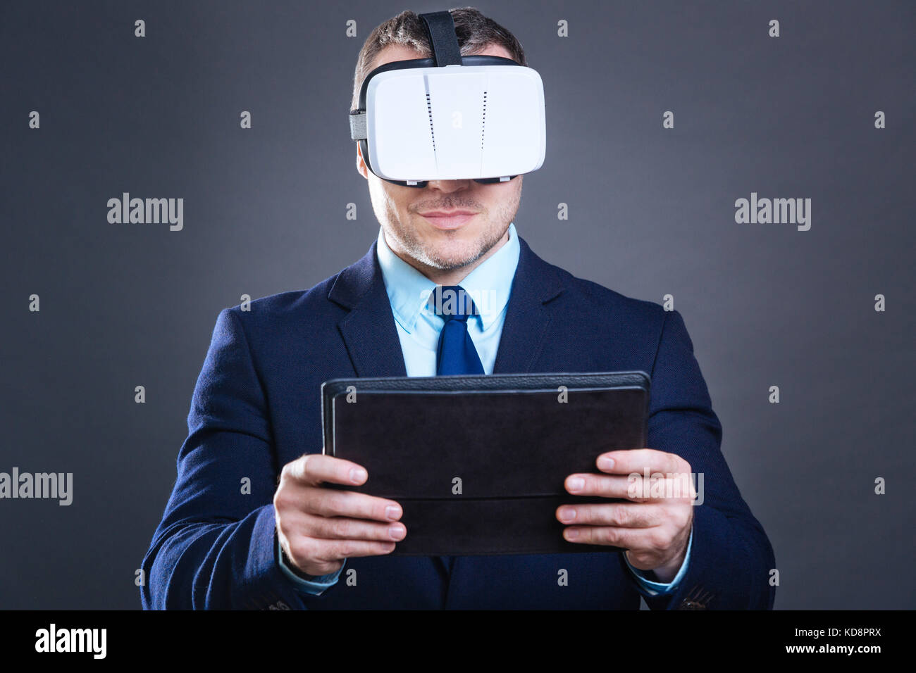 Delighted smart businessman standing with a tablet in his hands Stock ...