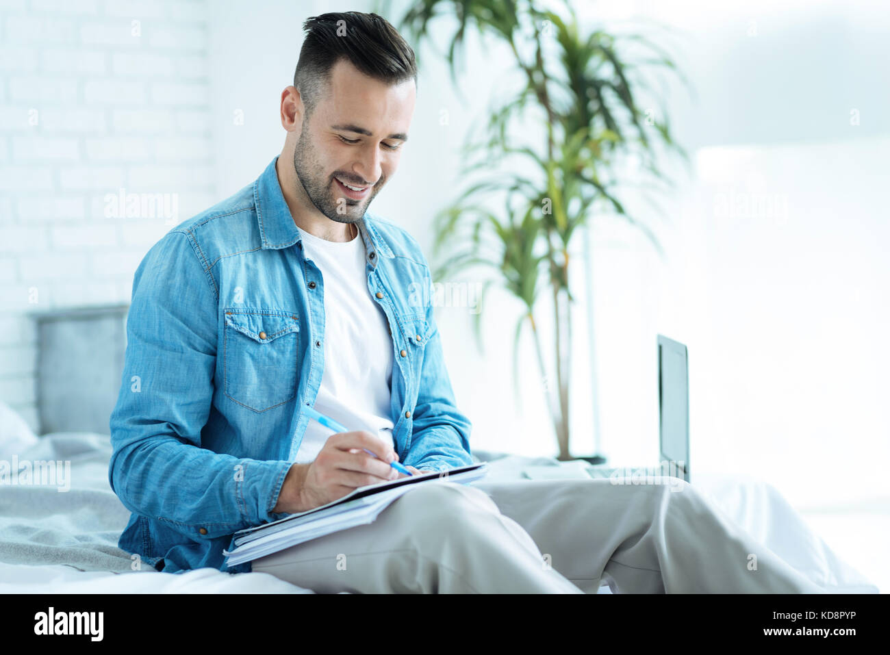 Diligent male student studying at home and smiling Stock Photo - Alamy