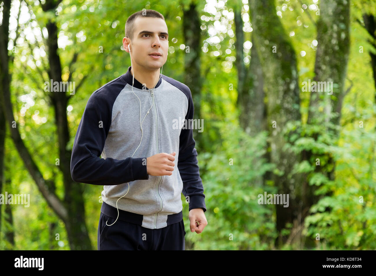 A man in sports clothes running around in the park Stock Photo - Alamy