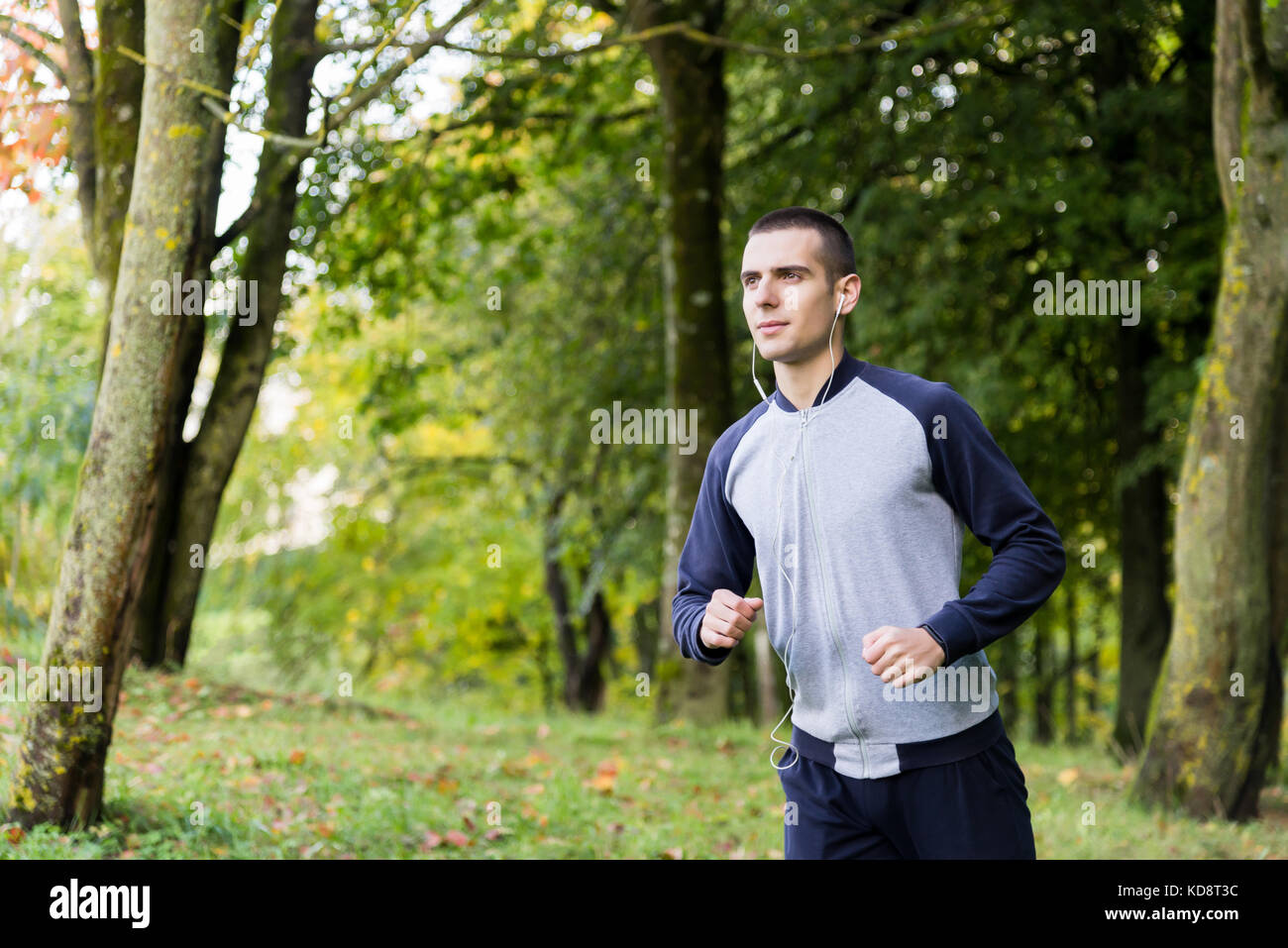 A man in sports clothes running around in the park Stock Photo - Alamy