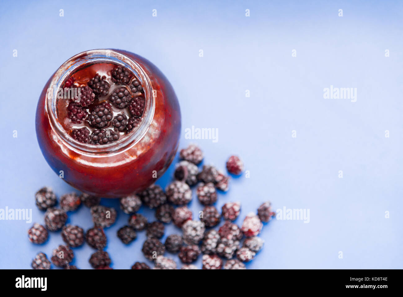 Glass jar with jam on a blue background Stock Photo - Alamy