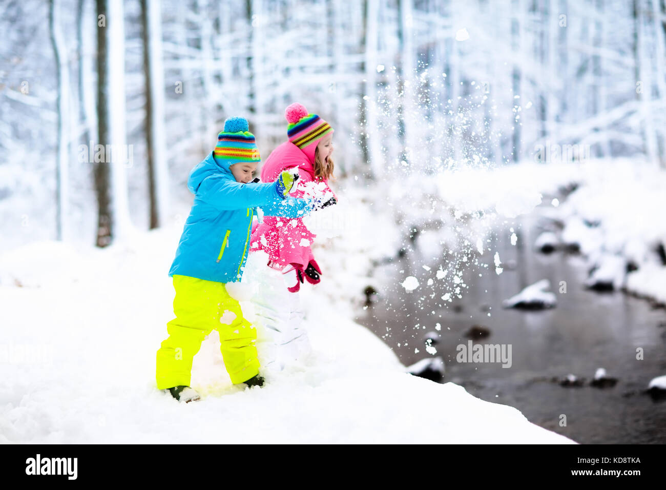 Kids playing in snow. Children play outdoors on snowy winter day. Boy ...