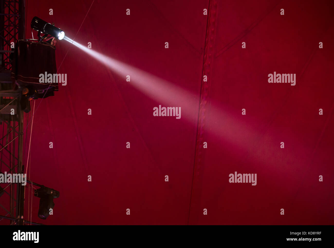 Limelight and red background on the scene. Flood lighting in the circus ...