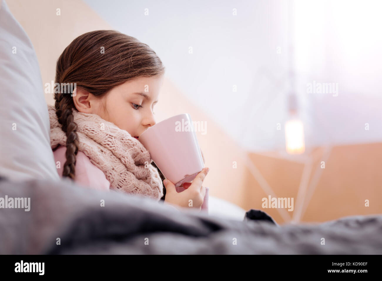 Sad girl with bunches drinking tea Stock Photo - Alamy
