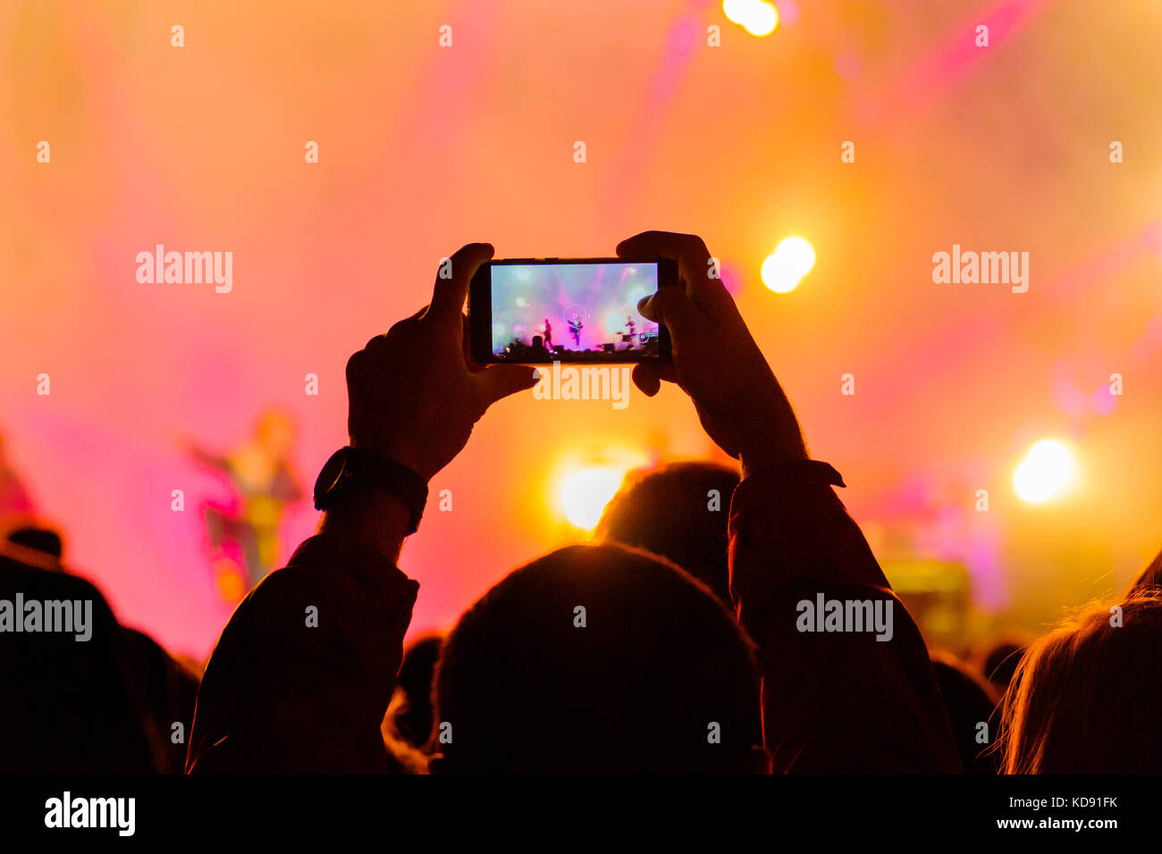 Concert visitor shoots video on a smartphone Stock Photo - Alamy