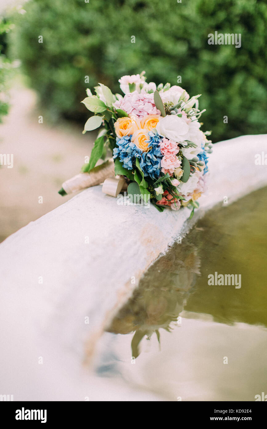 Side view of the wedding bouquet of colourful flowers and roses placed ...
