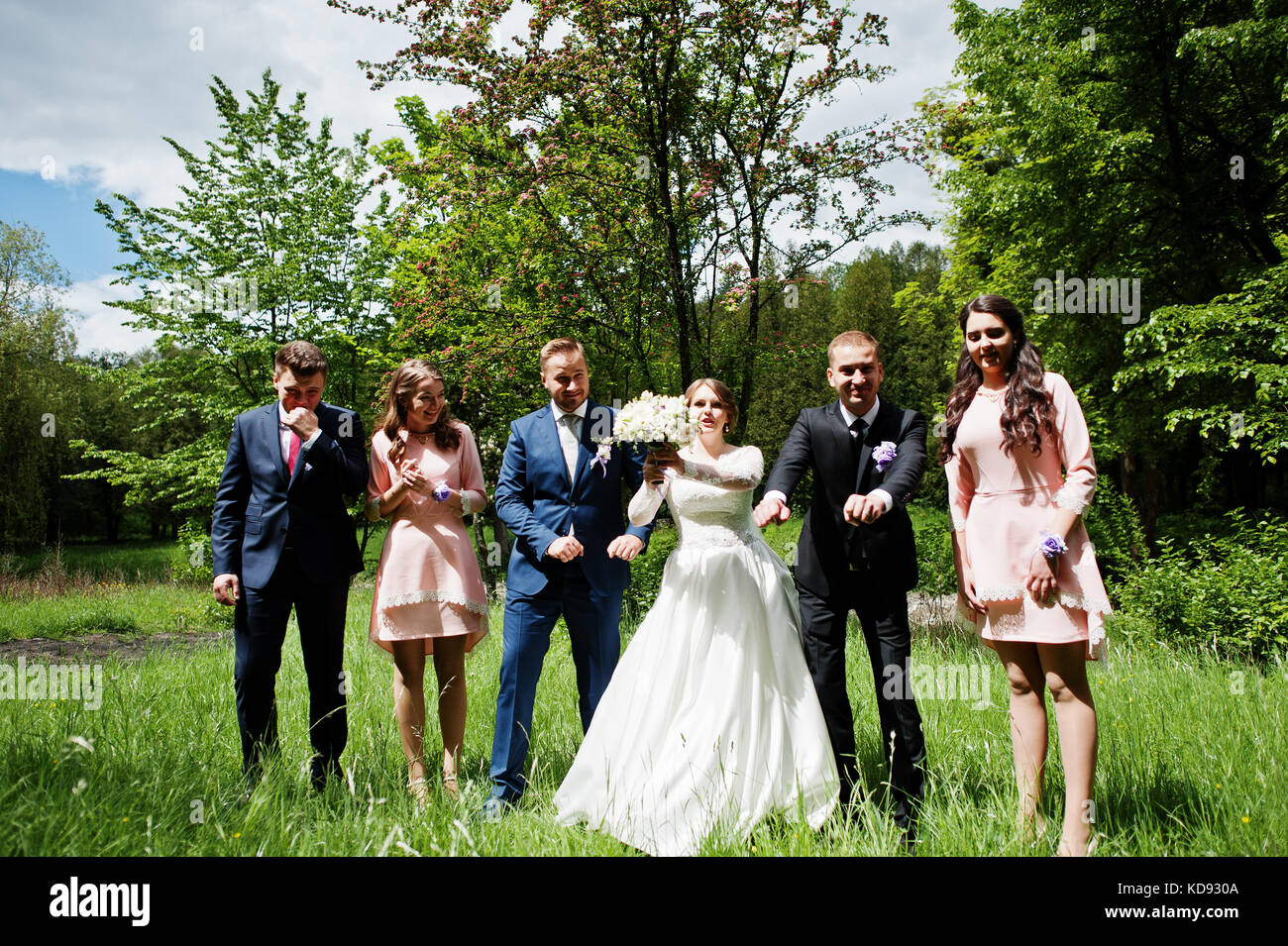 Crazy and happy newlyweds having fun with bridesmaids and groomsmen in ...