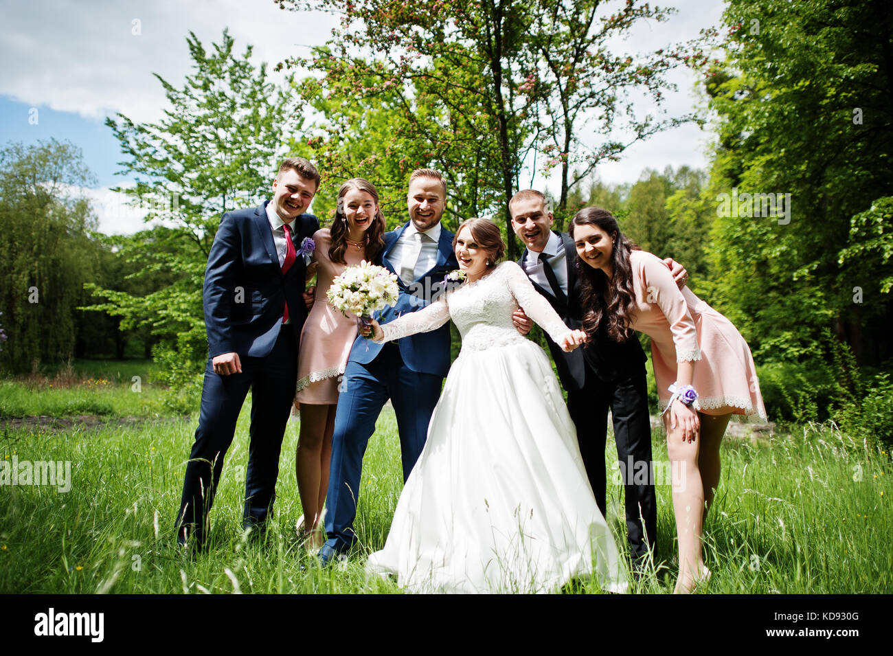 Crazy and happy newlyweds having fun with bridesmaids and groomsmen in ...
