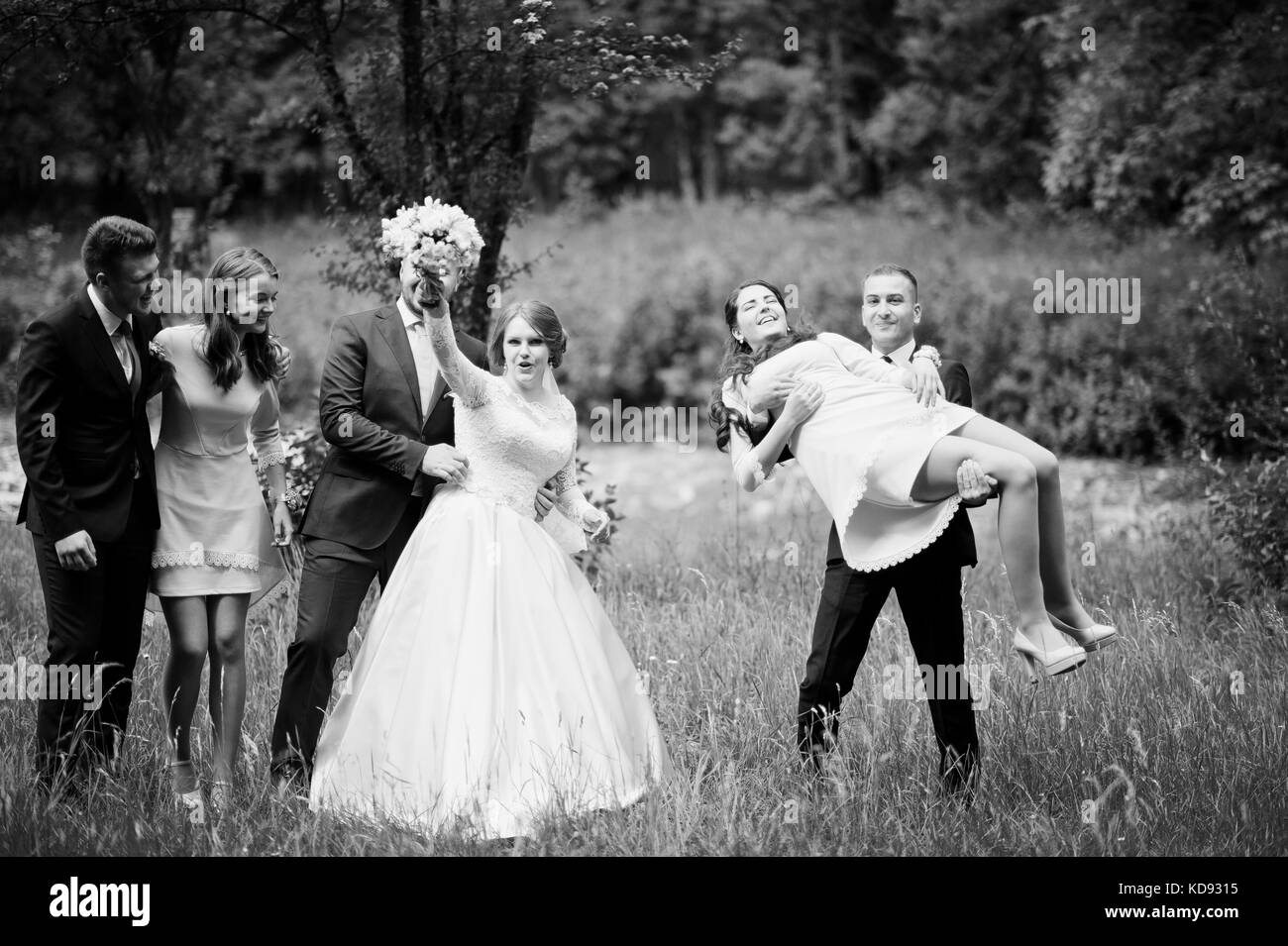 Crazy and happy newlyweds having fun with bridesmaids and groomsmen in ...