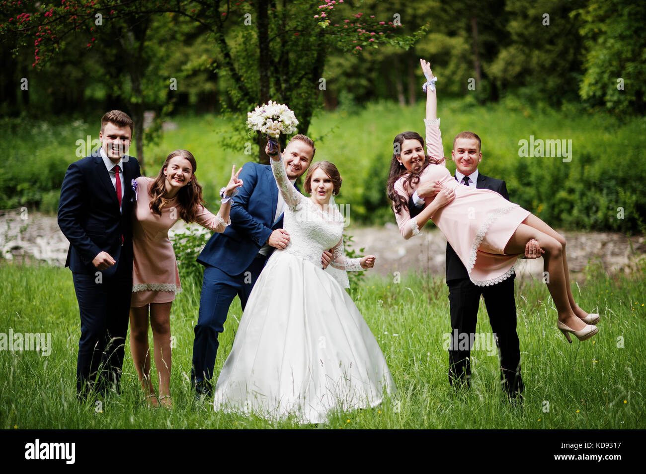Crazy and happy newlyweds having fun with bridesmaids and groomsmen in ...