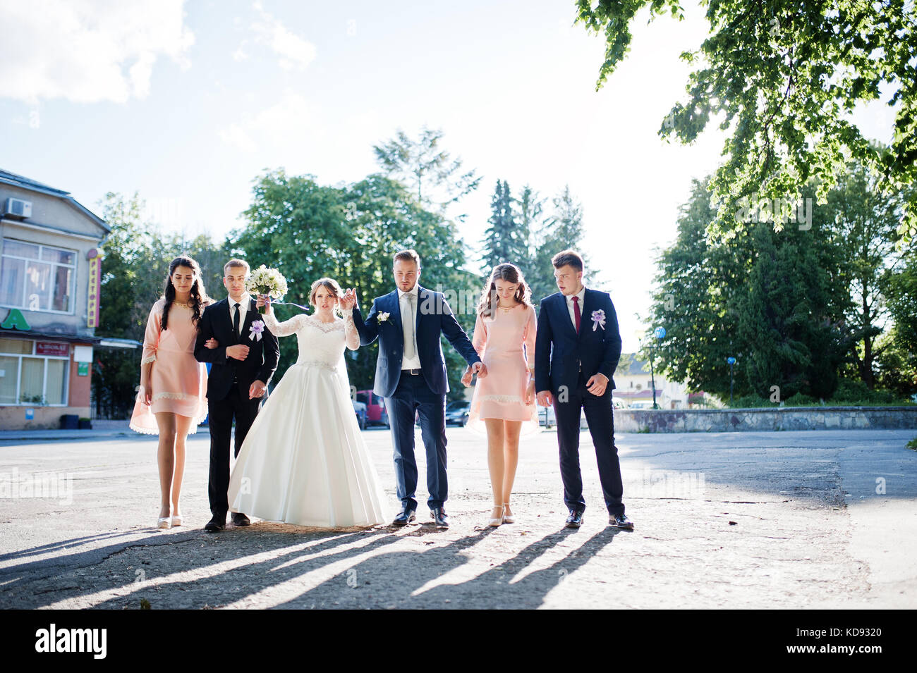 Happy wedding couple and bridesmids with groomsmen running and jumping ...