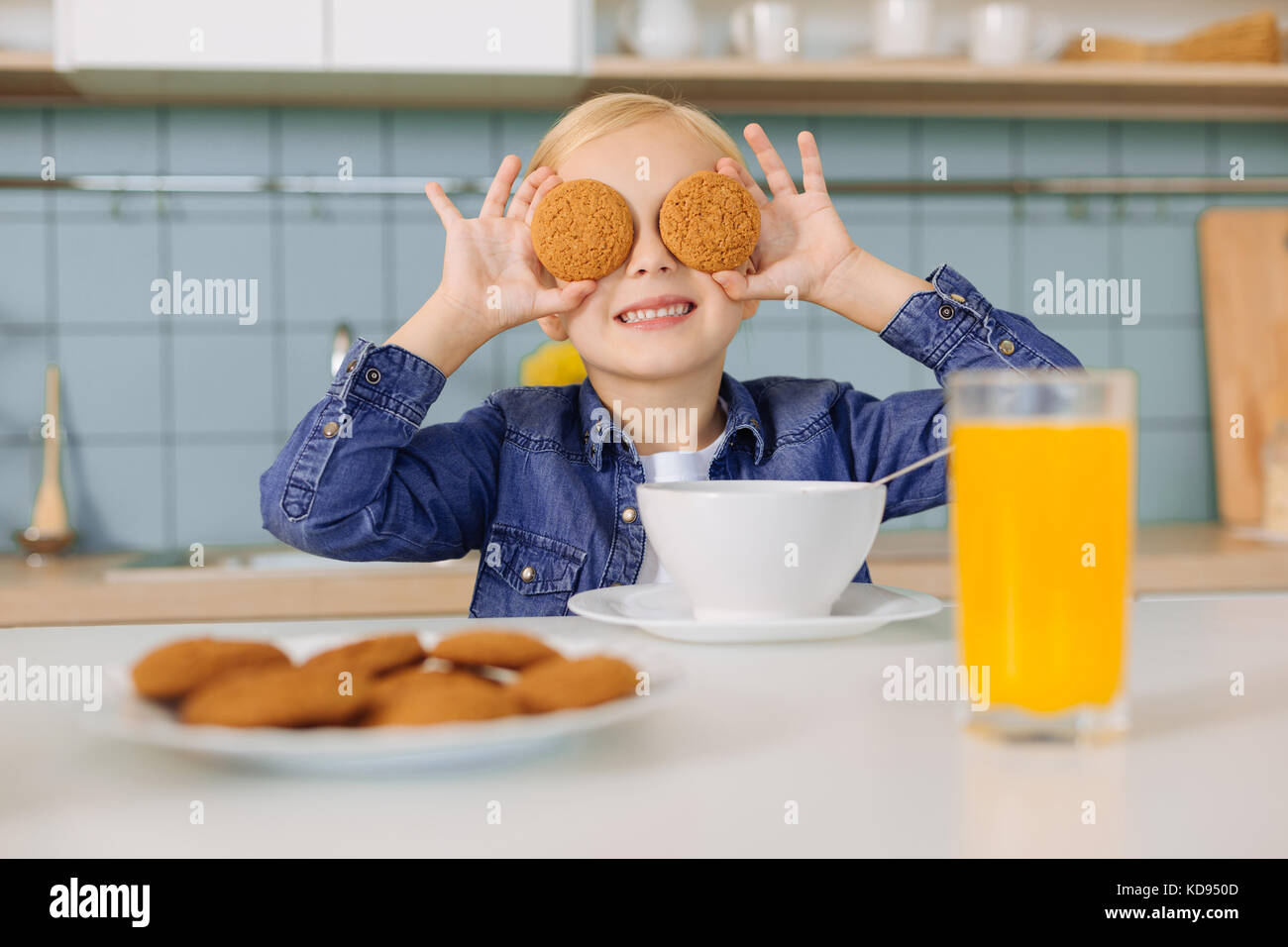 Happy nice girl putting cookies to her eyes Stock Photo - Alamy