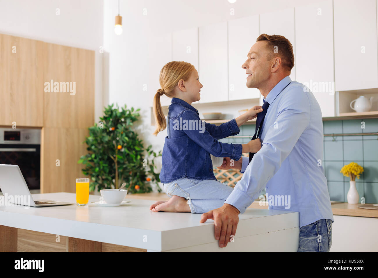 Nice positive girl sitting on the table Stock Photo - Alamy