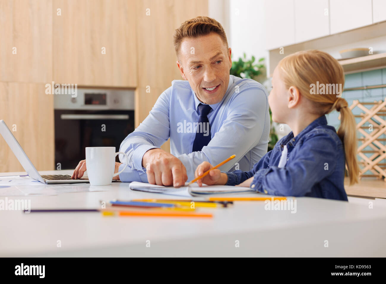 Intelligent nice man helping his daughter with her hometask Stock Photo - Alamy