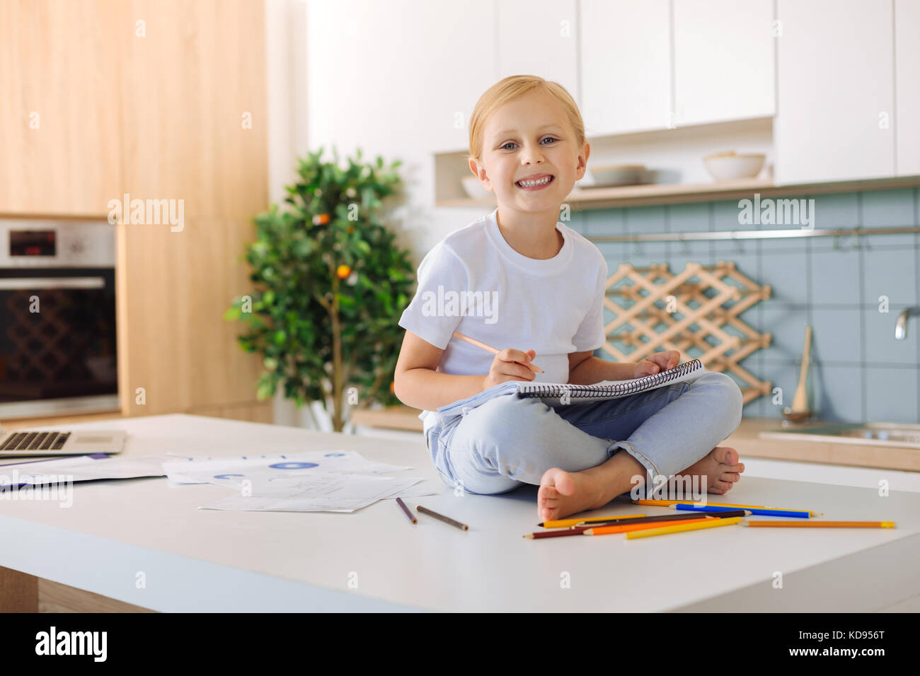 Cheerful nice girl sitting cross legged Stock Photo - Alamy