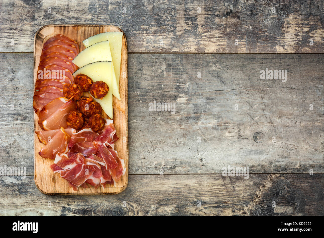Spanish cold cuts (embutidos). Cheese, sausage and ham on wooden table ...