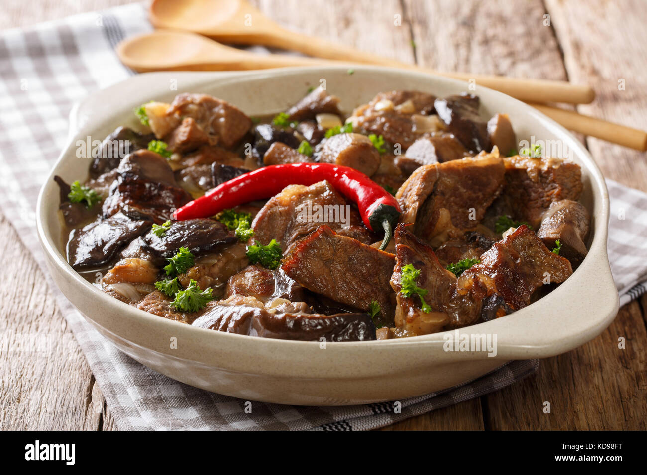 Spicy beef with wild mushrooms, chili pepper and gravy closeup in a ...