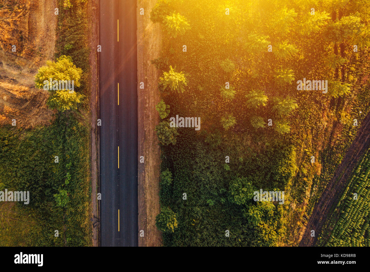Empty straight road through countryside in sunset, aerial view from ...