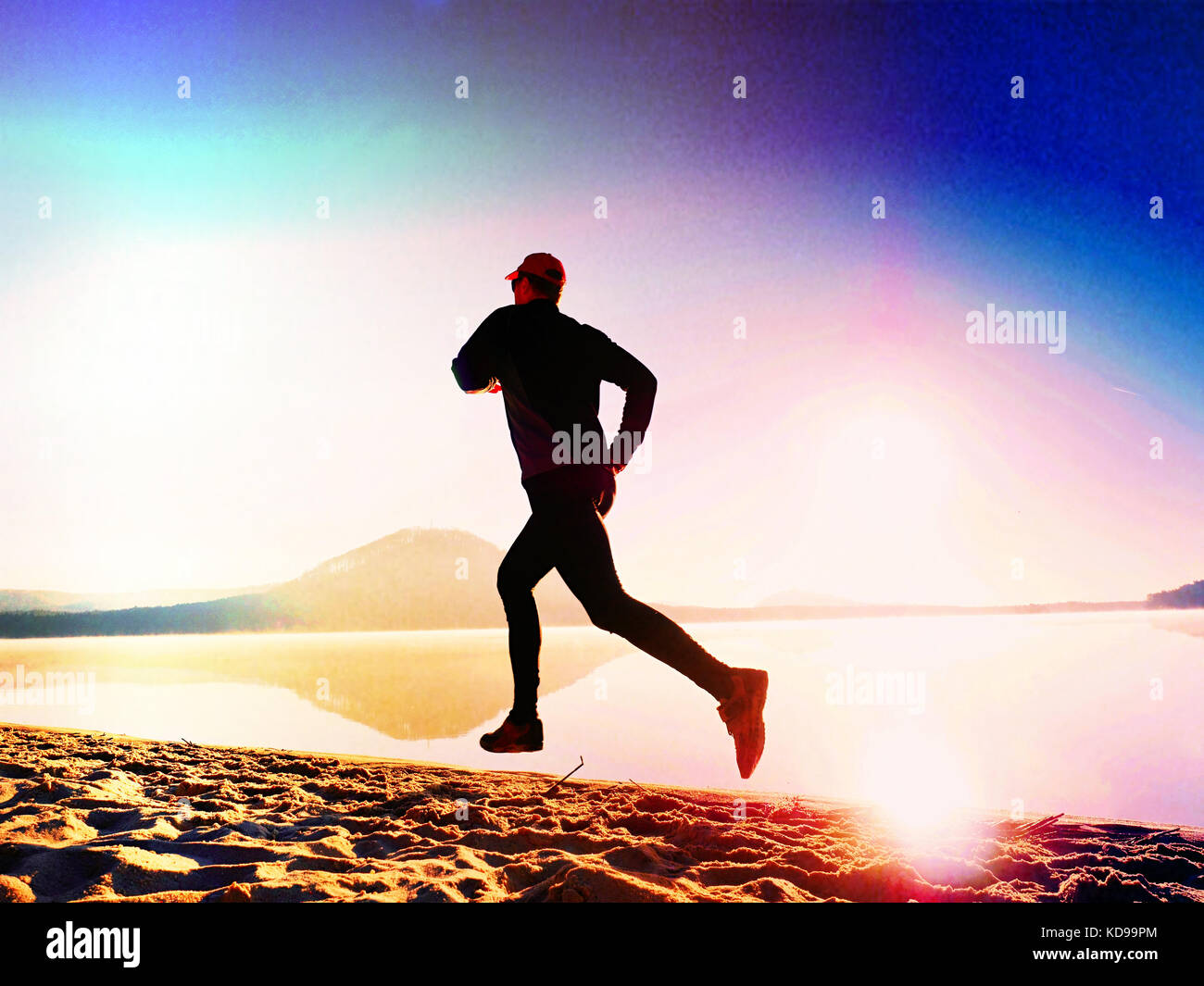 Lens defect. Tall fit man running along the sea shore in morning ...