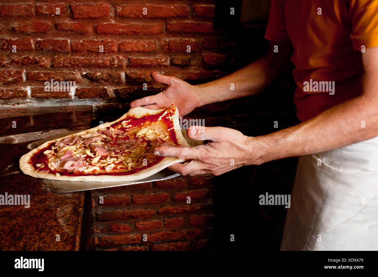 Hands stretching the pizza Stock Photo - Alamy