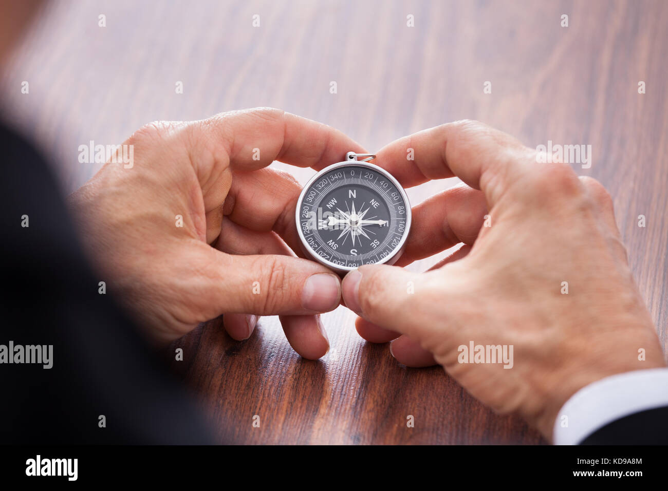 Close-up Of Hand Holding Compass On White Background Stock Photo - Alamy