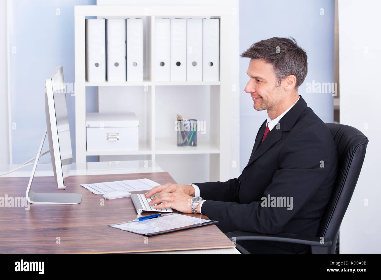 Portrait Of Mature Businessman Using Computer At Desk Stock Photo - Alamy